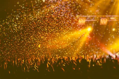 장면 무대 주황색과 노란색 조명 록 쇼 공연 사람들의 실루엣 콘서트 축제 중 댄스 플로어 공기에서 발사 된 화려한 색종이 조각 폭발 공연에 대한 스톡 사진 및 기타 이미지