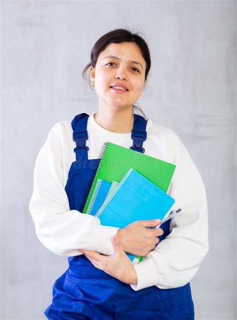 Positive Female Builder In Blue Jumpsuit Holding Engineering