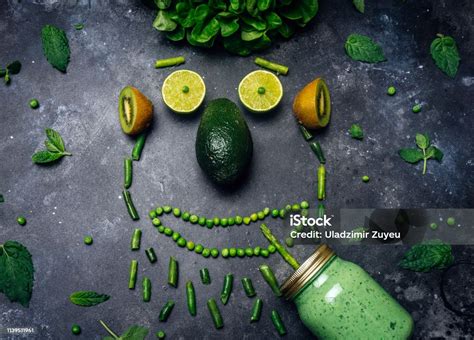 그린 디 톡 스 건강 스무디 그린 과일 아보카도 샐러드 케 일 라임 키 위 민트 음식 얼굴 아이 아이디어를 위한 재미 있는 음식 알칼리 성 다이어트 개념입니다 비 건 건강