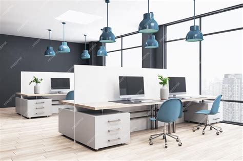 컴퓨터 파란색 의자가 있는 밝은 빈 공동 작업 공간 큰 창문 검은색 벽 흰색 파티션 나무 바닥과 콘크리트 천장 작업 공간 내부 개념 3d 렌더링 프리미엄 사진