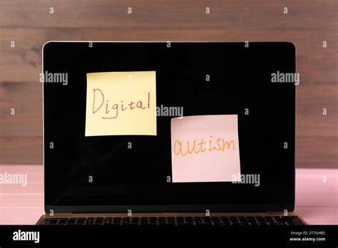 Sticky Notes With Phrase Digital Autism Attached To Laptop On Table