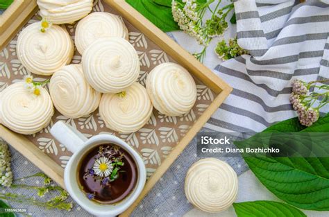 머랭 홈메이드 제퍼 마시멜로 나무 쟁반에 담긴 허브차 한 잔 면 식탁보에 양념 허브 모형 카드 요리법 책 또는 음식 메뉴 템플릿