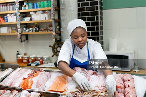 해산물 시장에서 일하는 아프리카계 미국인 여성이 얼음이 담긴 용기에 다양한 제품을 진열하고 있다 뼈 없는 부드러운 살에 대한