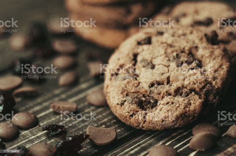 초콜릿 조각과 설탕에 절인 과일을 곁들인 오트밀 쿠키가 나무 테이블에 놓여 있습니다 소박한 테이블입니다 빈티지 토닝 글루텐이없는 식이 유용한 쿠키 공간을 복사합니다 갈색에