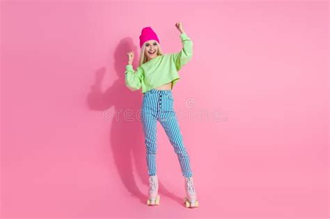 Young Trendy Woman In Colorful Fashion On Roller Skates Celebrates And
