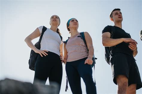 Friends Hike Through A Forest Landscape Wearing Sportswear And