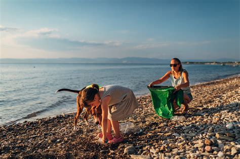 여성 환경 운동가가 귀여운 작은 딸의 도움으로 플라스틱 쓰레기로부터 해변을 청소합니다 가족에 대한 스톡 사진 및 기타 이미지 가족 쓰레기 해변 Istock
