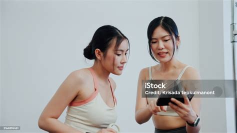 Two Asian Women Learning Pilates Moves From Online Class Before