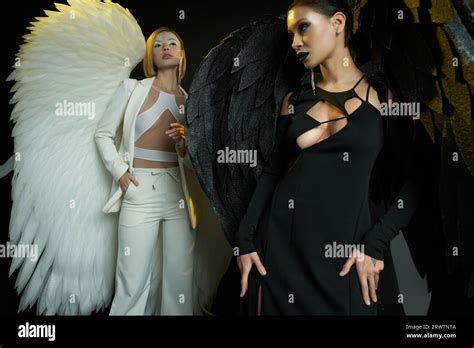Women In Costumes Of Angel And Demon On Black Backdrop Biblical Battle