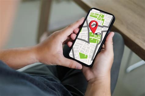Gps 지도를 들고 스마트폰을 사용하여 손 목적지 네트워크 연결 위치 Gps 아이콘 탐색이 있는 거리 지도 프리미엄 사진
