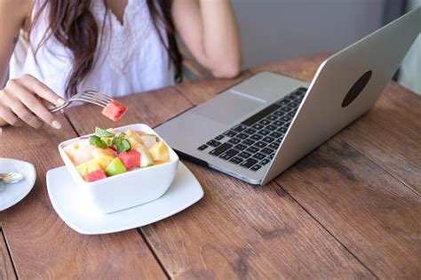 커피와 밖에 서 일하고 여자입니다 열 대 호텔에서 그녀의 휴가 기간 동안 노트북에 작업 화이트 화이트 드레스와 함께 여성입니다