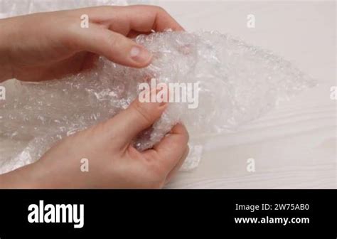 Woman Presses A Bubble Wrap Female Hands Burst Air Bubbles On A Bubble