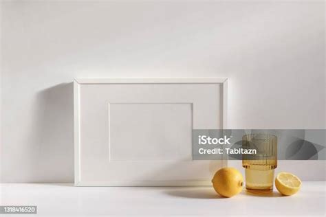 여름 문구는 여전히 생활 장면 레몬 과일을 잘라 햇빛에 베이지 색 테이블 배경에 물 황금 파문 유리 빈 흰색 수평 액자 모형 샴페인 벽 긴 그림자 0명에 대한 스톡 사진 및