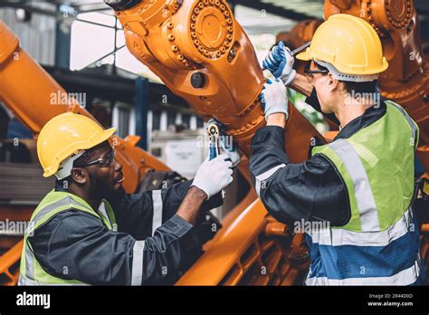 Engineer Working Service Maintenance Robot Arm Welding In Assembly Line