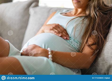 Mid-section of Pregnant Woman Sitting in Sofa with Her Hands at Belly Stock Image - Image of ...