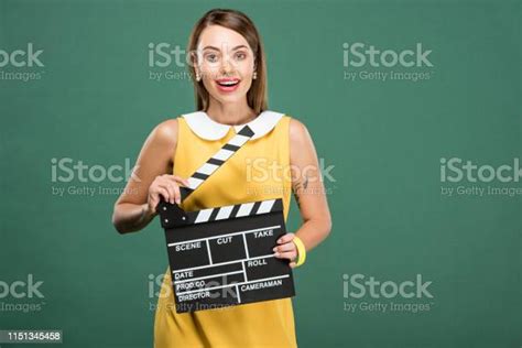 녹색에 고립 된 카메라와 지주 필름 클 래퍼 보드를 보고 노란 드레스에 아름 다운 세련 된 여자 노랑에 대한 스톡 사진 및 기타 이미지 Istock
