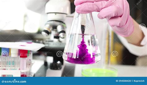 Scientist Chemist Dripping Pink Liquid Into Glass Flask With Water In Laboratory Closeup 4k