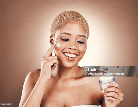 모이스처라이저 제품 크림 흑인 여성이 스튜디오에서 뷰티 스킨케어와 페이스 로션으로 미소를 짓고 있다 갈색 배경 얼굴에 화장과