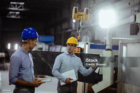 공장 홀에서 엔지니어 품질 관리를 수행 자동화 된 프로세스와 로봇으로 현대 산업 홀에서 제조 직업 금속 가공 산업 및 창고 공장