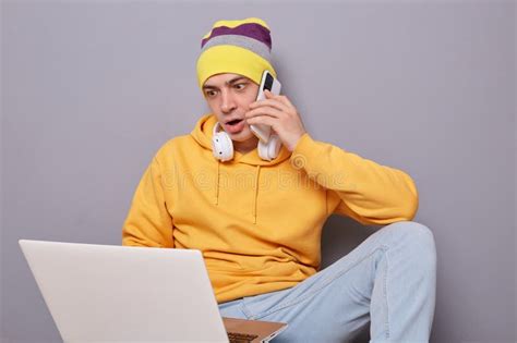 Portrait Of Shocked Man Wearing Beanie Hat Yellow Hoodie And Jeans