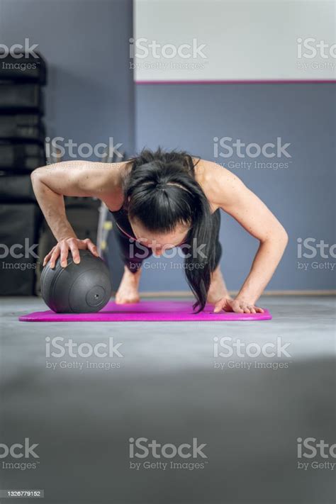 Vertical Shot Of An Asian Woman Performing Arm Pushups With One Hand