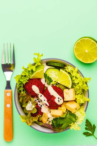 근대 미트볼 야채 Tahini 드레싱과 구운된 두 부 채식주의 부처님 그릇 녹색 배경 평면도 복사 공간입니다 건강 한 채식 음식