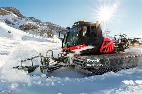 오스트리아의 알파인 스키 윈터 리조트 이쉬글에서 스키 슬로프 피스트 힐을 준비하는 스노우플러 스노우 그루밍 머신이 있는 레드