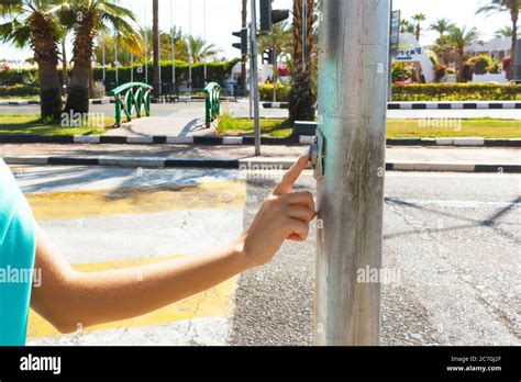The Girl Pushes A Pedestrian Crossing Button On The Road Waiting For The Green Light Stock