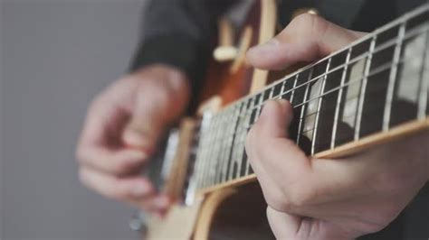 Man Hands Playing Electric Guitar Pulling And Pushing Strings Close Up