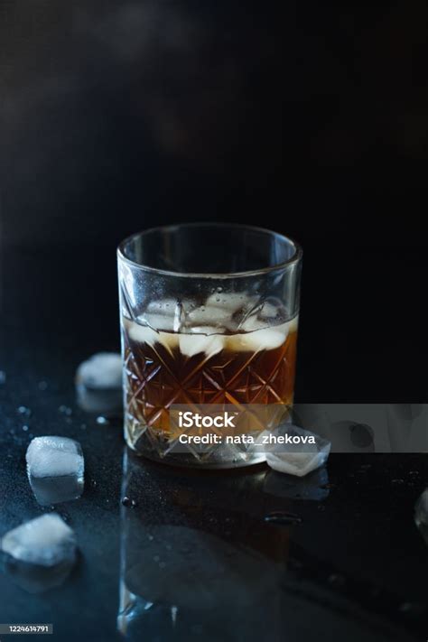검은 돌 테이블에 얼음과 위스키 또는 버번 의 유리 얼음과 사각형 디켄터와 위스키 한 잔 스카치 위스키와 얼음 한 잔 0명에