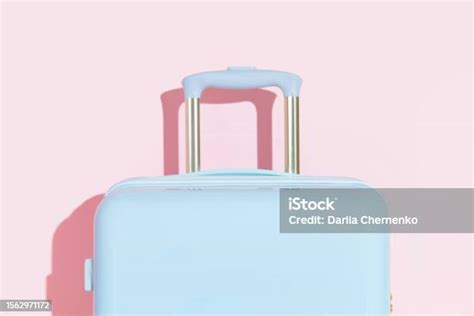 길고 짙은 그림자가 있는 파스텔 핑크 배경에 파란색 여행 가방 여행 컨셉 0명에 대한 스톡 사진 및 기타 이미지 0명 가방 개념 Istock