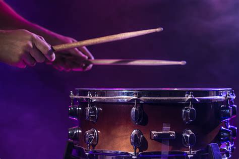 드러머가 드럼을 연주합니다 빛의 광선과 아름다운 파란색과 빨간색 배경 아름다운 특수 효과 연기와 조명 악기 를 연주하는 과정 클로즈업 사진 가지 식물 부위에 대한 스톡 사진