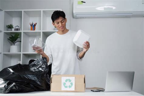 Young Man Comparing Recyclable Containers In Eco Friendly Workspace Promoting Sustainable