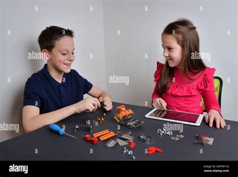 Girl And Boy Build Robot With Tools Programming With Tablet Concept