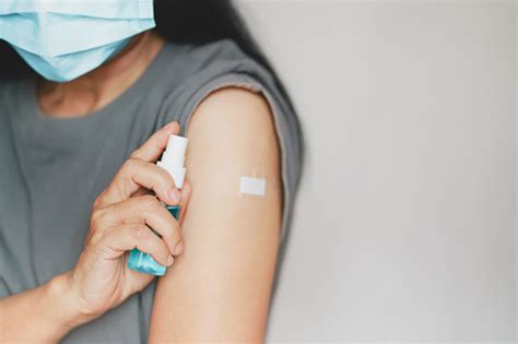 코로나 바이러스 인구 사회 또는 무리 면역 개념의 확산으로 인해 예방 접종 또는 접종 부스터 복용량 후 의료 얼굴 마스크를 착용 스프레이 알코올 병을 들고 시니어 손 건강