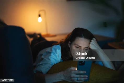 소파에 누워 집에서 밤에 스마트폰 화면을 보고 있는 젊은 진지한 슬픈 여자 전화에 대한 스톡 사진 및 기타 이미지 전화 밤 하루 시간대 사람들 Istock