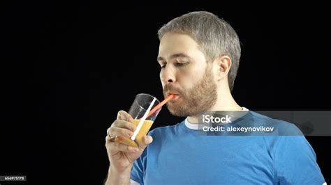 빨대와 오렌지 주스를 마시는 파란색 티셔츠에 운동 수염 회색 머리 남자 검은 색 배경 T 셔츠에 대한 스톡 사진 및 기타 이미지 T 셔츠 검정색 배경 그루터기 얼굴