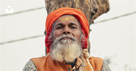 수염과 주황색 터번을 쓴 남자가 나무 앞에 서 있다 사진 Unsplash의 무료 인도 이미지