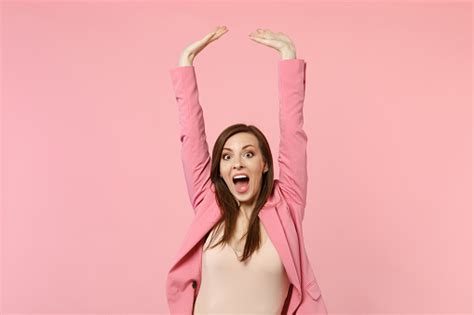 스튜디오에서 파스텔 분홍색 벽 배경에 고립 된 입 넓은 오픈 상승 손을 유지 쾌활 한 재미 아름 다운 젊은 여자의 초상화 사람들은 진심으로 감정 라이프 스타일 개념입니다