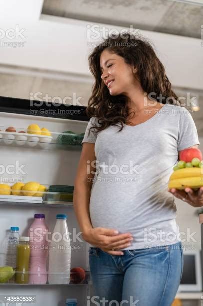 냉장고 앞에서 웃고 있는 아름다운 젊은 임신부 먹을 과일을 고르고 있다 임신 중 건강한 생활 방식 가정 주방에 대한 스톡 사진 및 기타 이미지 Istock