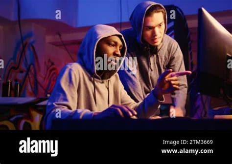 Hacker Talking To Asian Colleague In Rundown Hiding Place