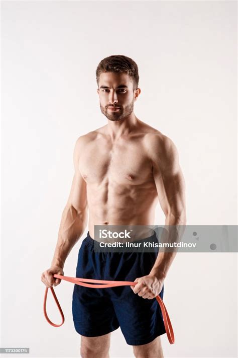그의 손에 체조 탄성 밴드와 흰색 배경에 수염을 가진 젊은 스포티 한 남자 고무 밴드로 훈련 강사에 대한 스톡 사진 및 기타 이미지 Istock