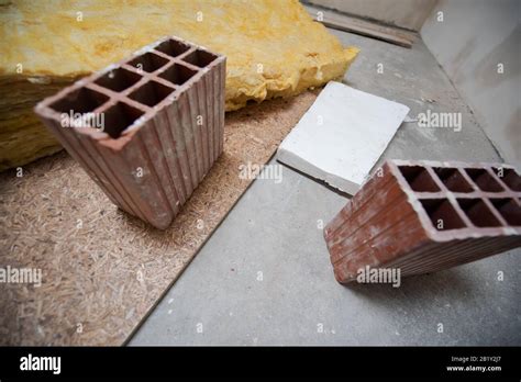 Red Bricks And Glass Wool Laying On The Concrete Floor At Construction