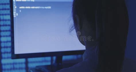 Portrait Of Young Woman Hacker Programmer Working At A Computer In The