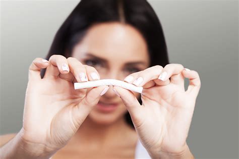 흡연을 중지 손에 담배를 들고 손가락으로 반으로 그것을 깨는 아름 다운 웃는 여자의 근접 촬영 초상화 종료 흡연 담배 개념 결정에 대한 스톡 사진 및 기타 이미지 Istock