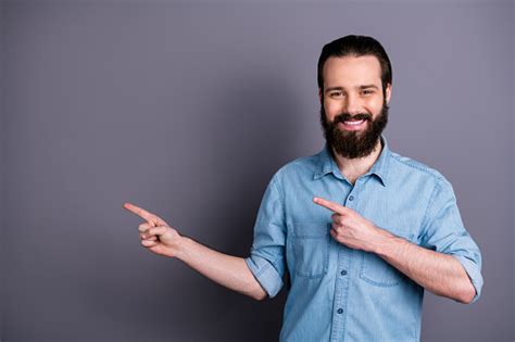 초상화 의 긍정적 인 쾌활한 자신감 남자 프로모터 포인트 집게 손가락 복사 공간 시연 광고 제시 프로모션 착용 좋은 모습 의상 회색 색상 배경 위에 고립 가리키기에 대한