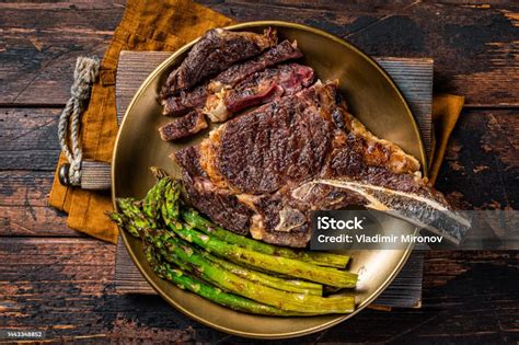 얇게 썬 구운 카우보이 또는 뼈 쇠고기 스테이크를 곁들인 갈비뼈 접시에 구운 아스파라거스 나무 배경입니다 상위 뷰 0명에 대한 스톡 사진 및 기타 이미지 Istock