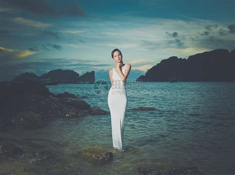美丽的女士穿着白色的连衣裙岩石海岸上高清图片下载 正版图片 摄图网