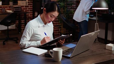premium stock video businesswoman crosschecking data between laptop