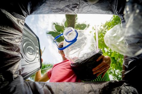 Premium Photo A Young Beautiful Girl Throws Sorted Garbage Into Special Bins